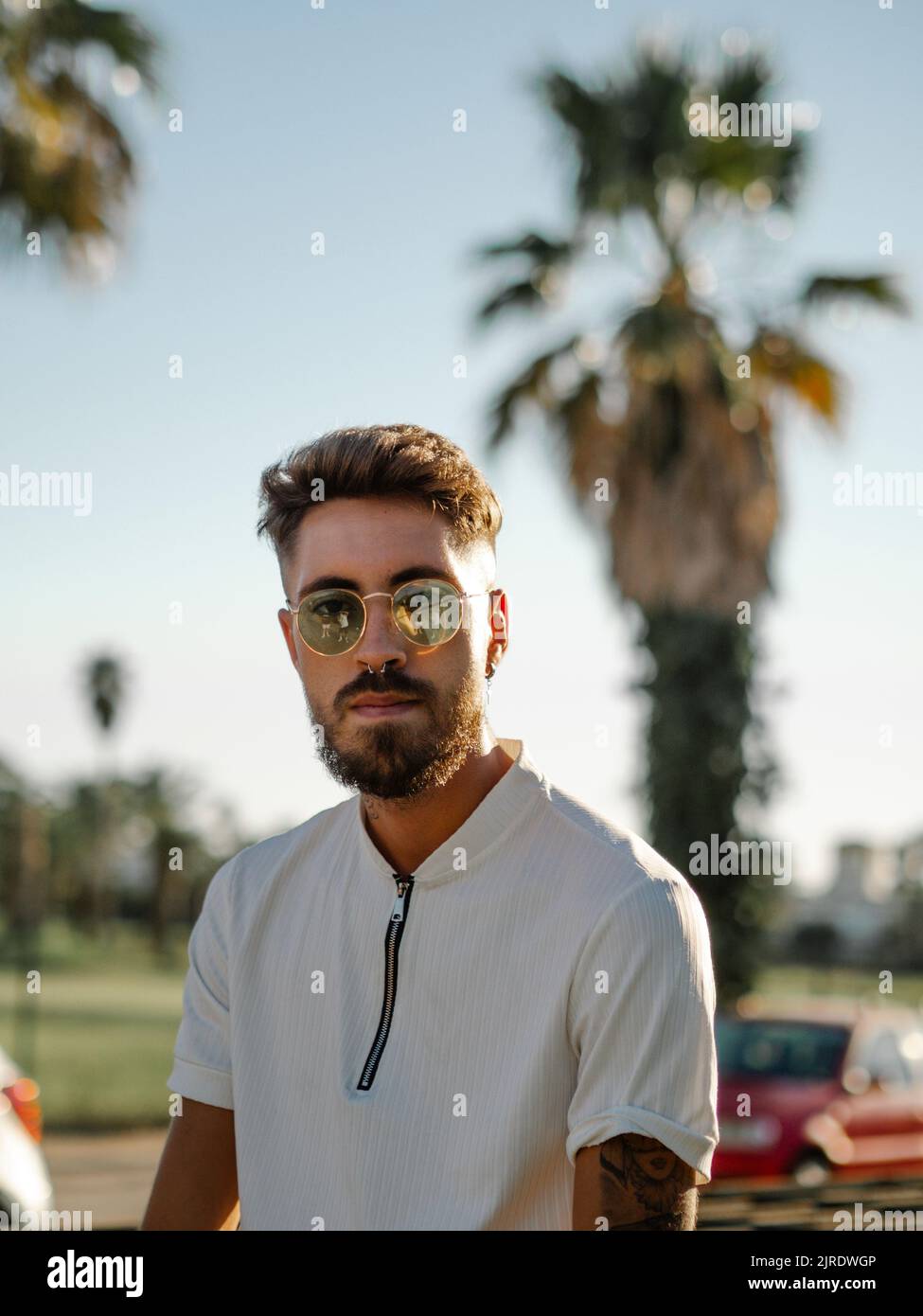 A young Spanish handsome man with a stylish hairstyle, tattoos, and ...