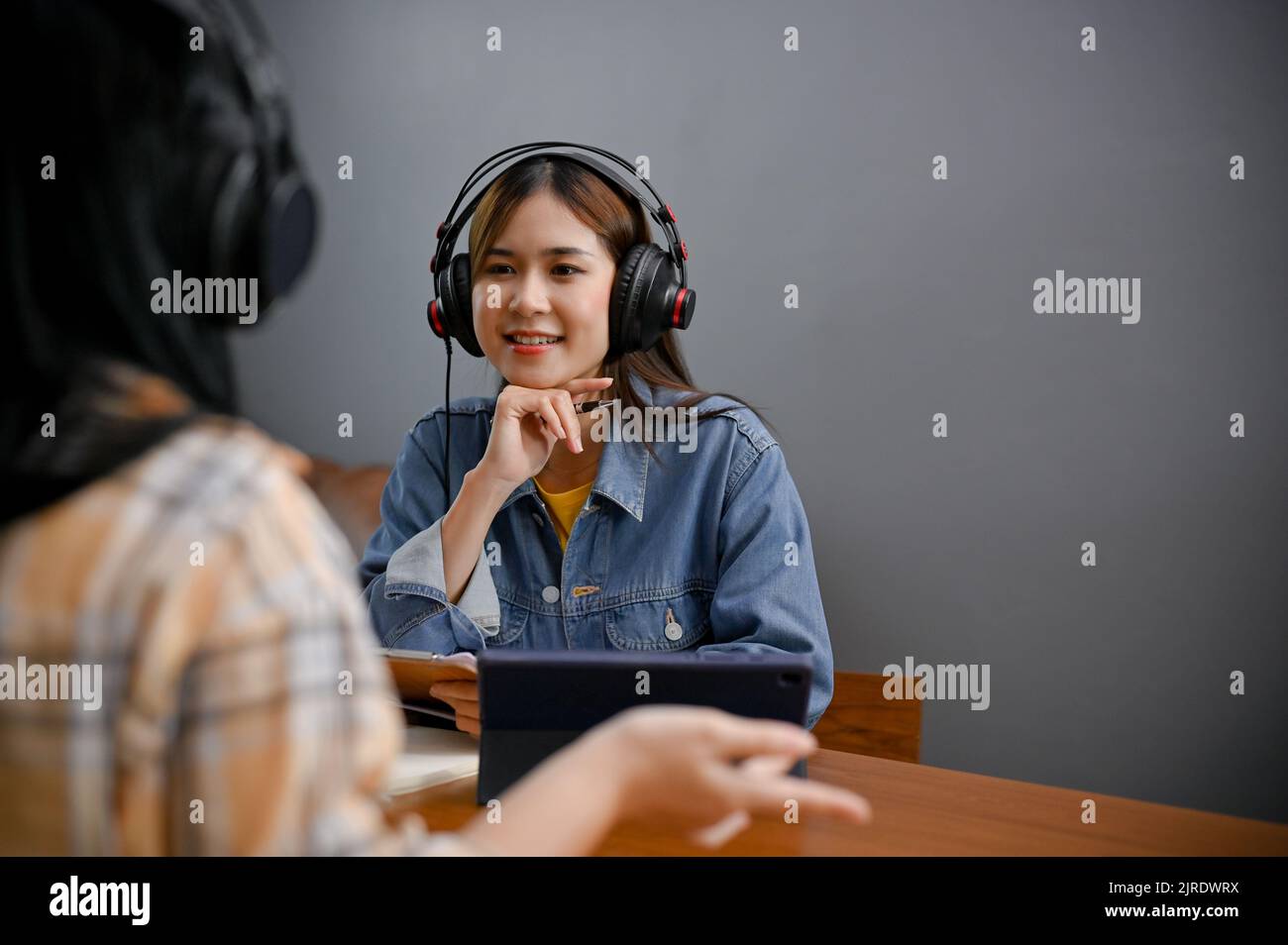 Friendly and attractive young Asian female and her friend running their ...