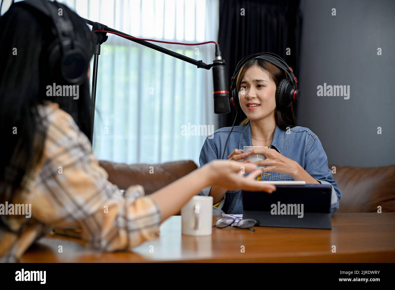 Beautiful young Asian female podcast radio host enjoys interviewing her ...