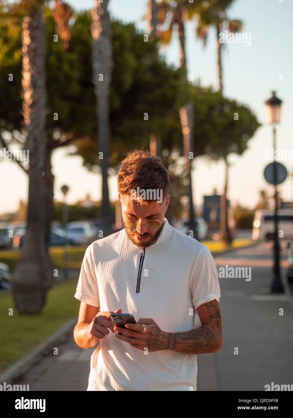 A young Spanish handsome man with a stylish hairstyle, tattoos, and ...