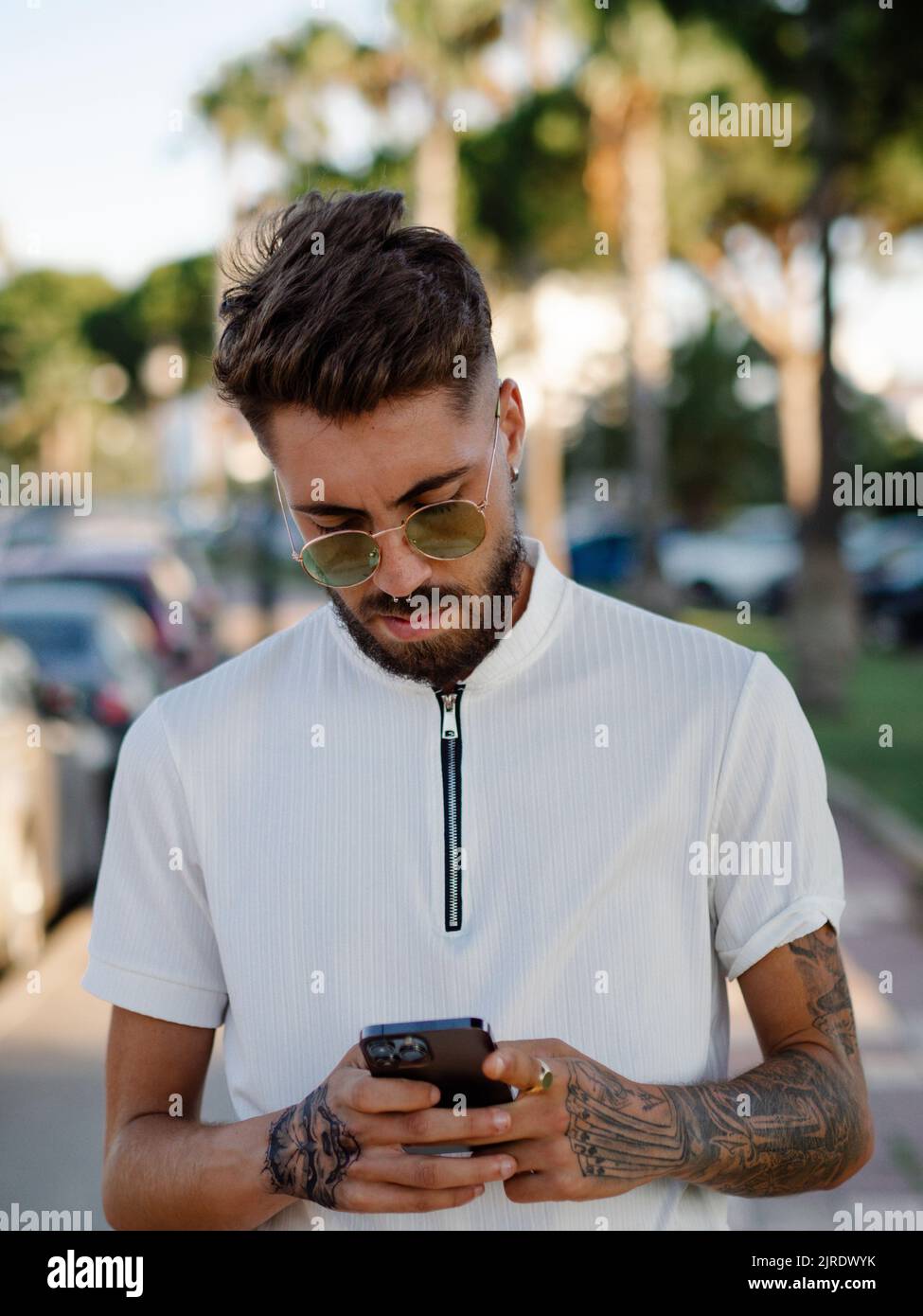 A young Spanish handsome man with a stylish hairstyle, tattoos, and ...