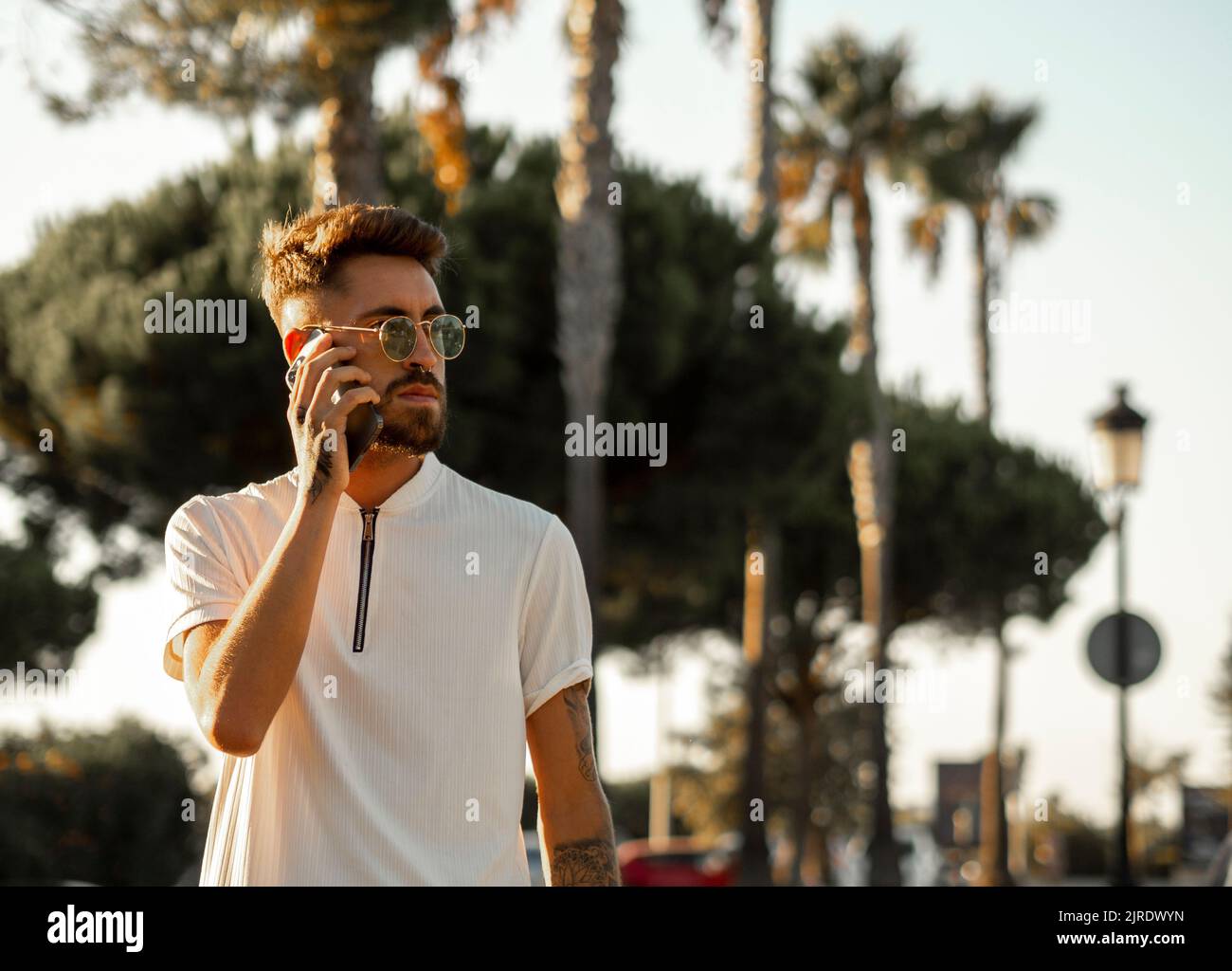 A young Spanish handsome man with a stylish hairstyle, tattoos, and ...