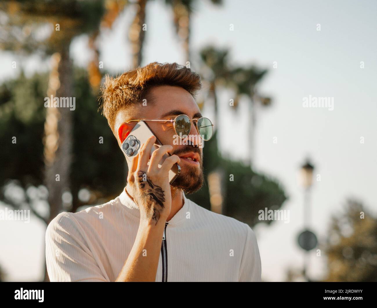 A young Spanish handsome man with a stylish hairstyle, tattoos, and ...