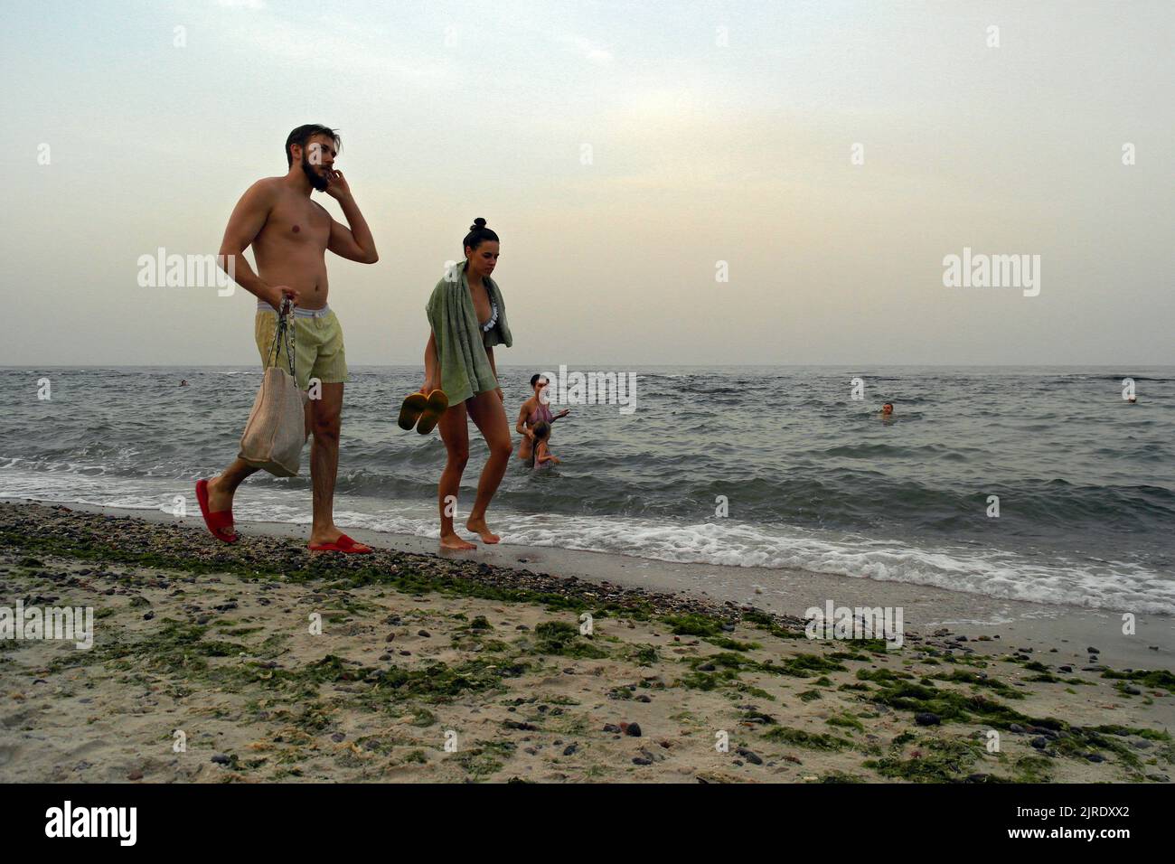 ODESA, UKRAINE - AUGUST 23, 2022 - People walk along the beach during ...