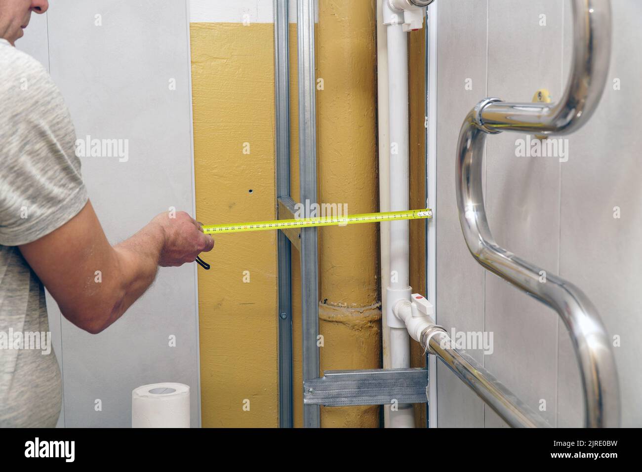 A man with a tape measure measures the wall for reconstruction. Man or ...