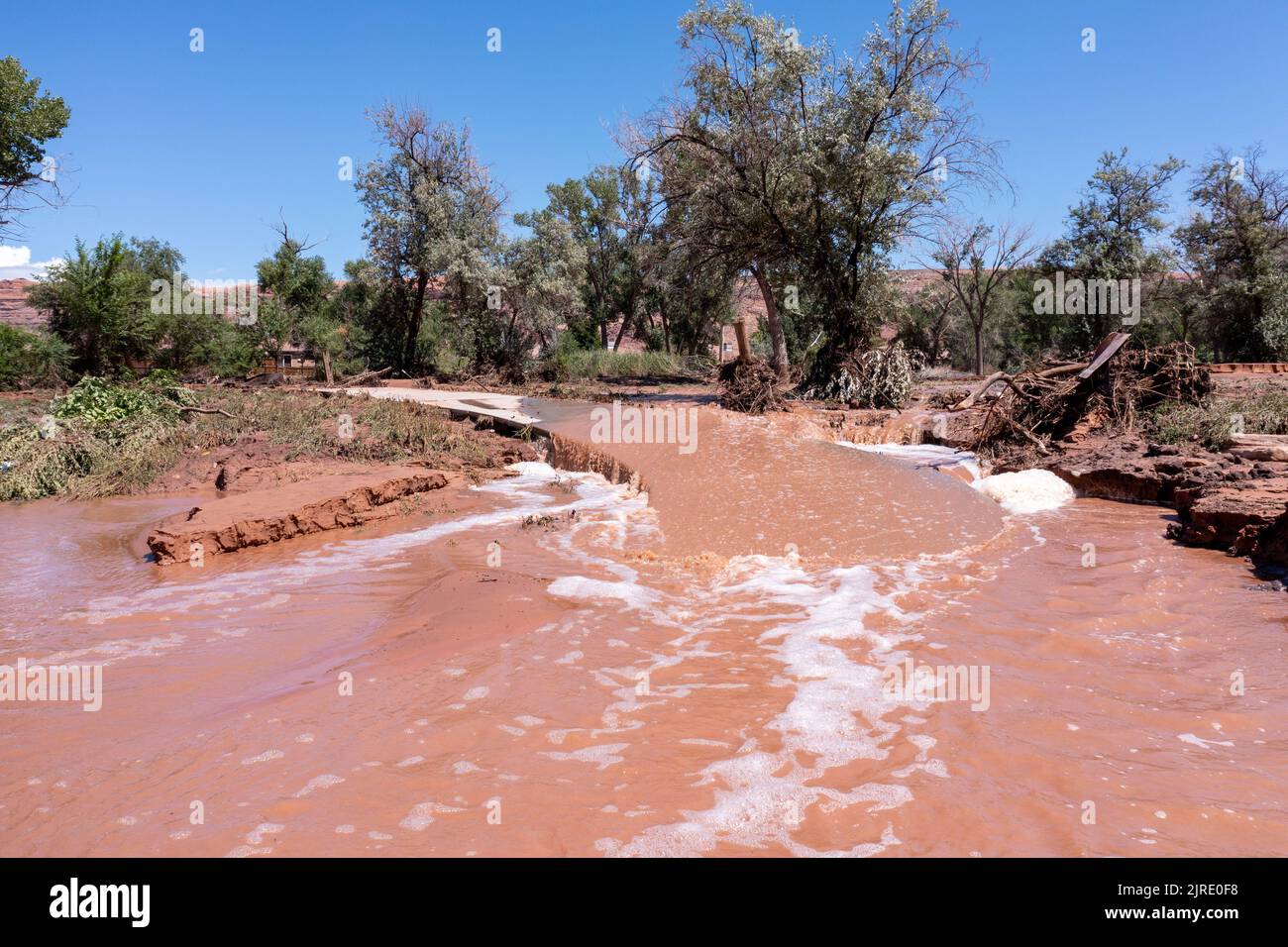 A low drone view of receding flood waters still flowing over the ...