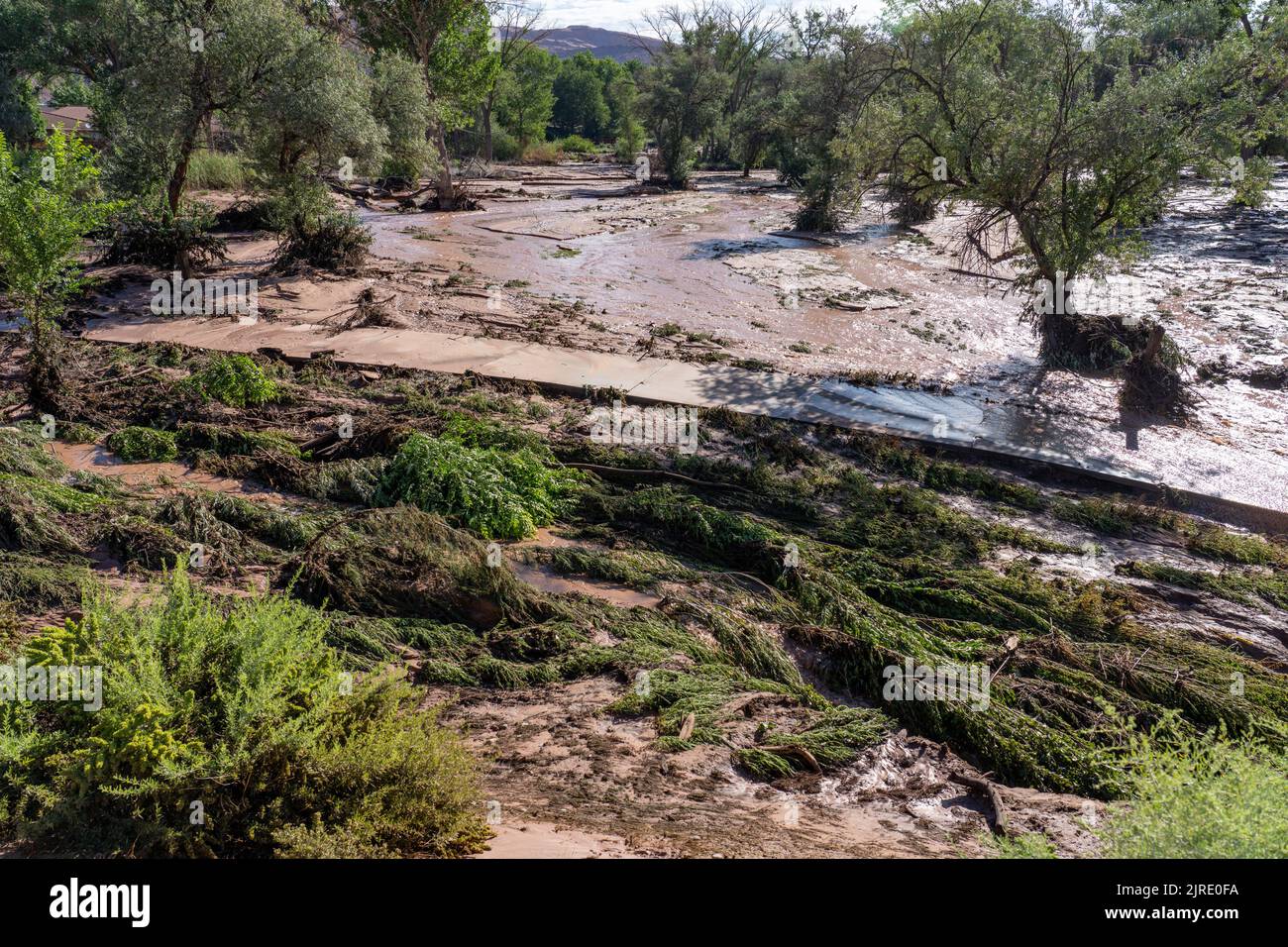 Receding flood waters still flowing over the flooded Mill Creek Parkway ...