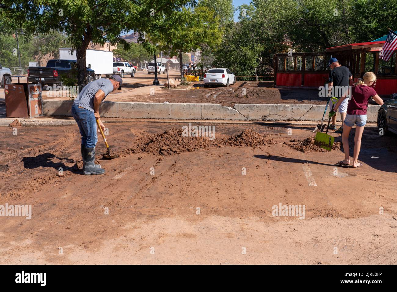 Volunteers shovel mud from the front of a local business the day after ...