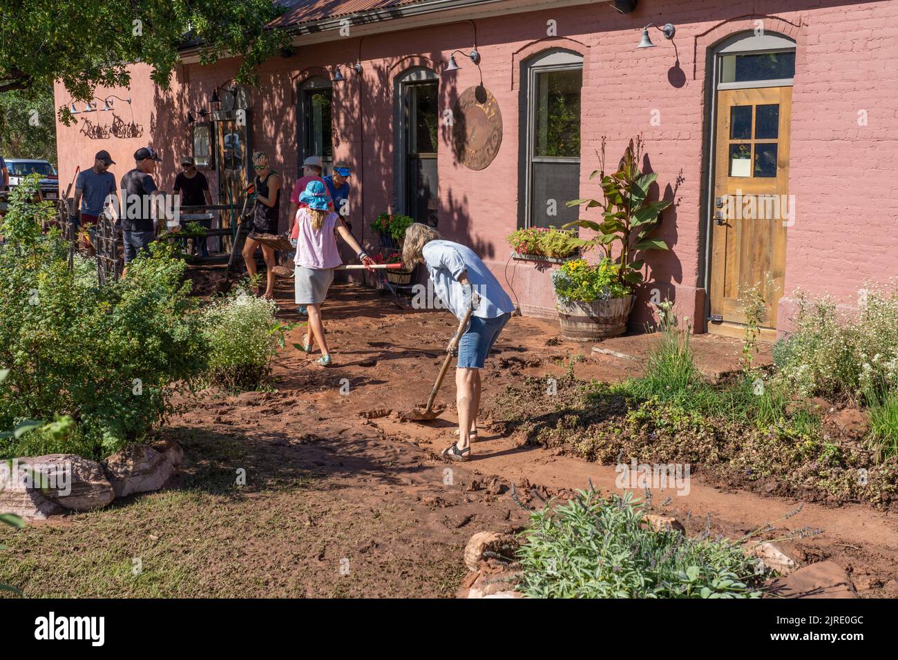 Volunteers shovel mud from the front of a local business the day after ...