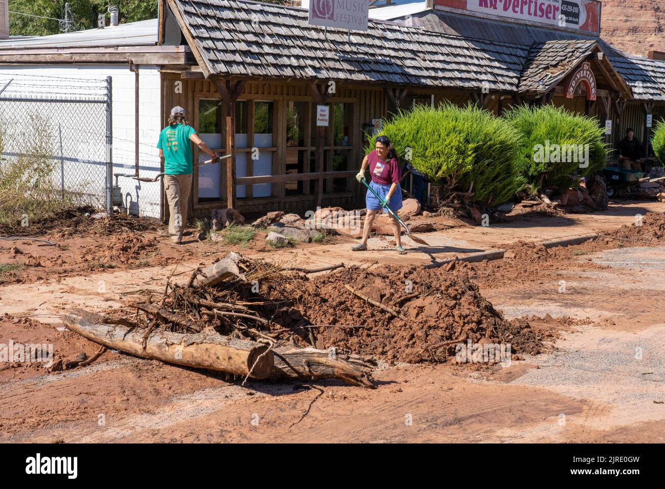 Volunteers shovel mud from the front of a local business the day after ...