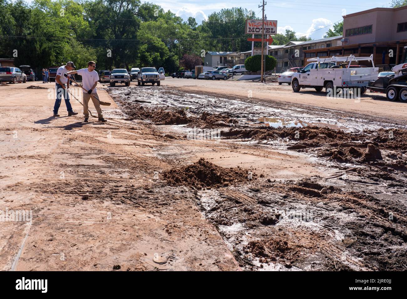 Volunteers shovel mud from the front of a local business the day after ...