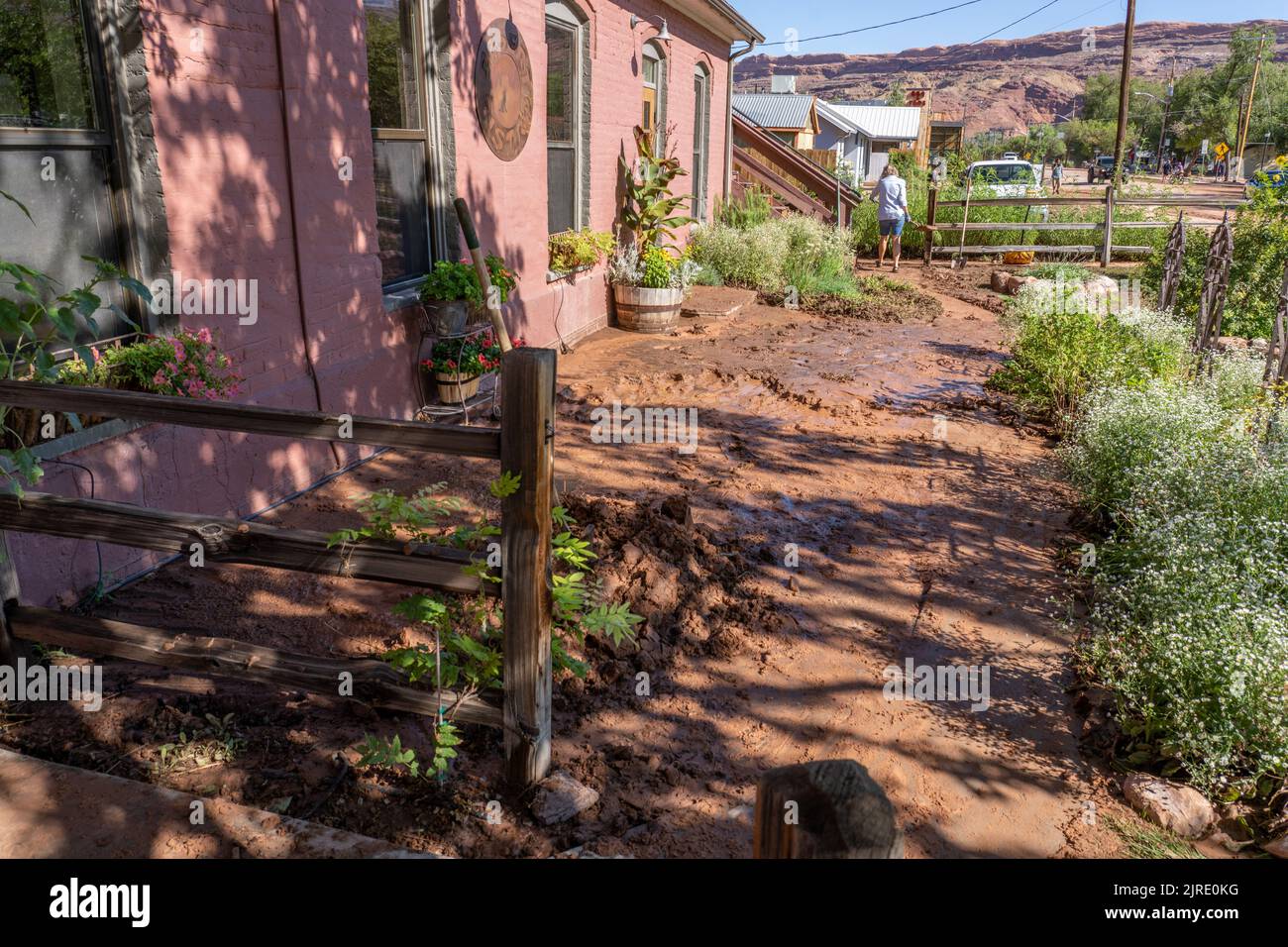 Volunteers shovel mud from the front of a local business the day after ...