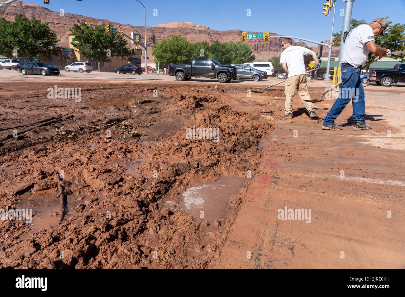 Volunteers shovel mud from the front of a local business the day after ...