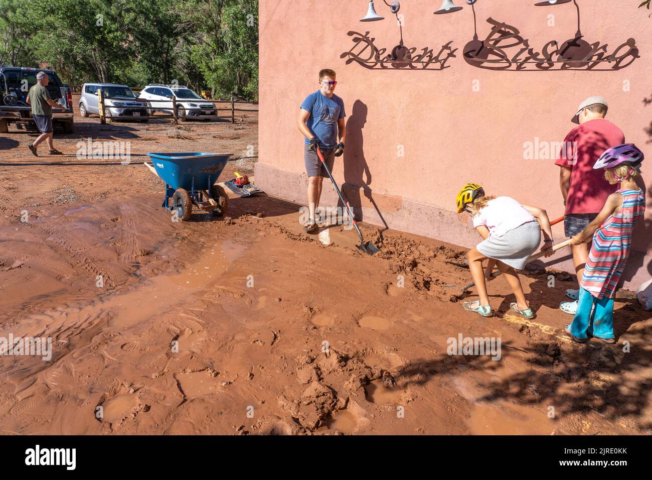 Volunteers shovel mud from the front of a local business the day after ...
