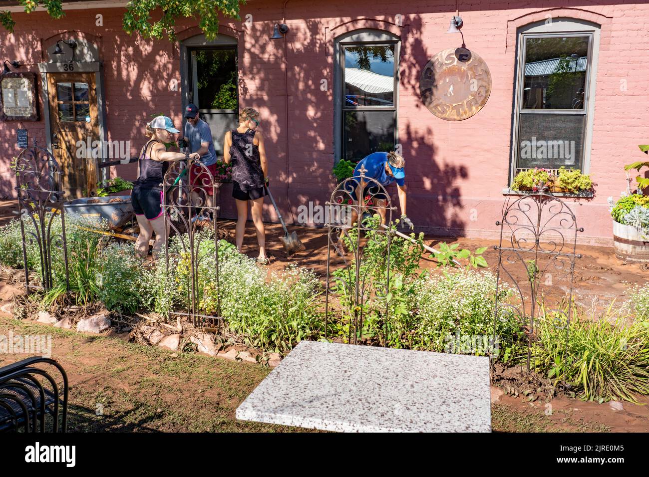 Volunteers shovel mud from the front of a local business the day after ...