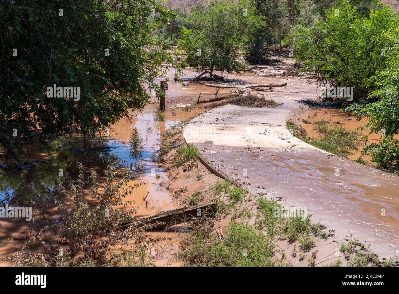 Receding flood waters still flowing over the flooded Mill Creek Parkway ...