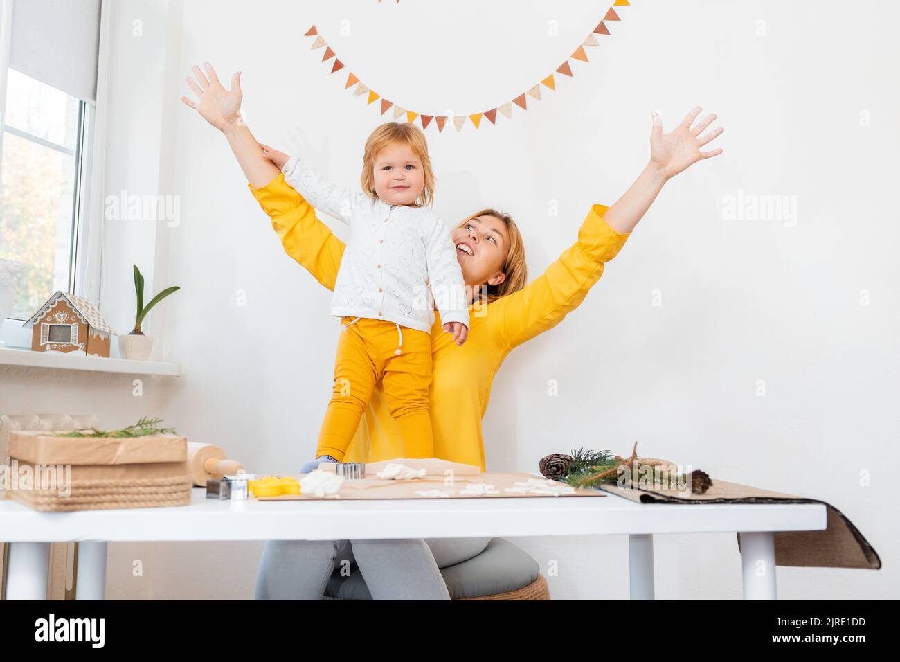 Happy mother and child have fun together. Needlework table near the ...