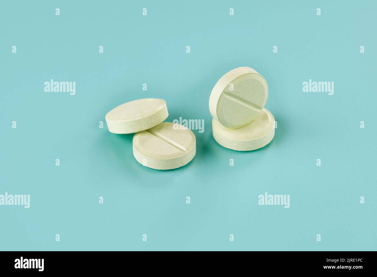 four white tablets with a center line on a cyan background Stock Photo ...