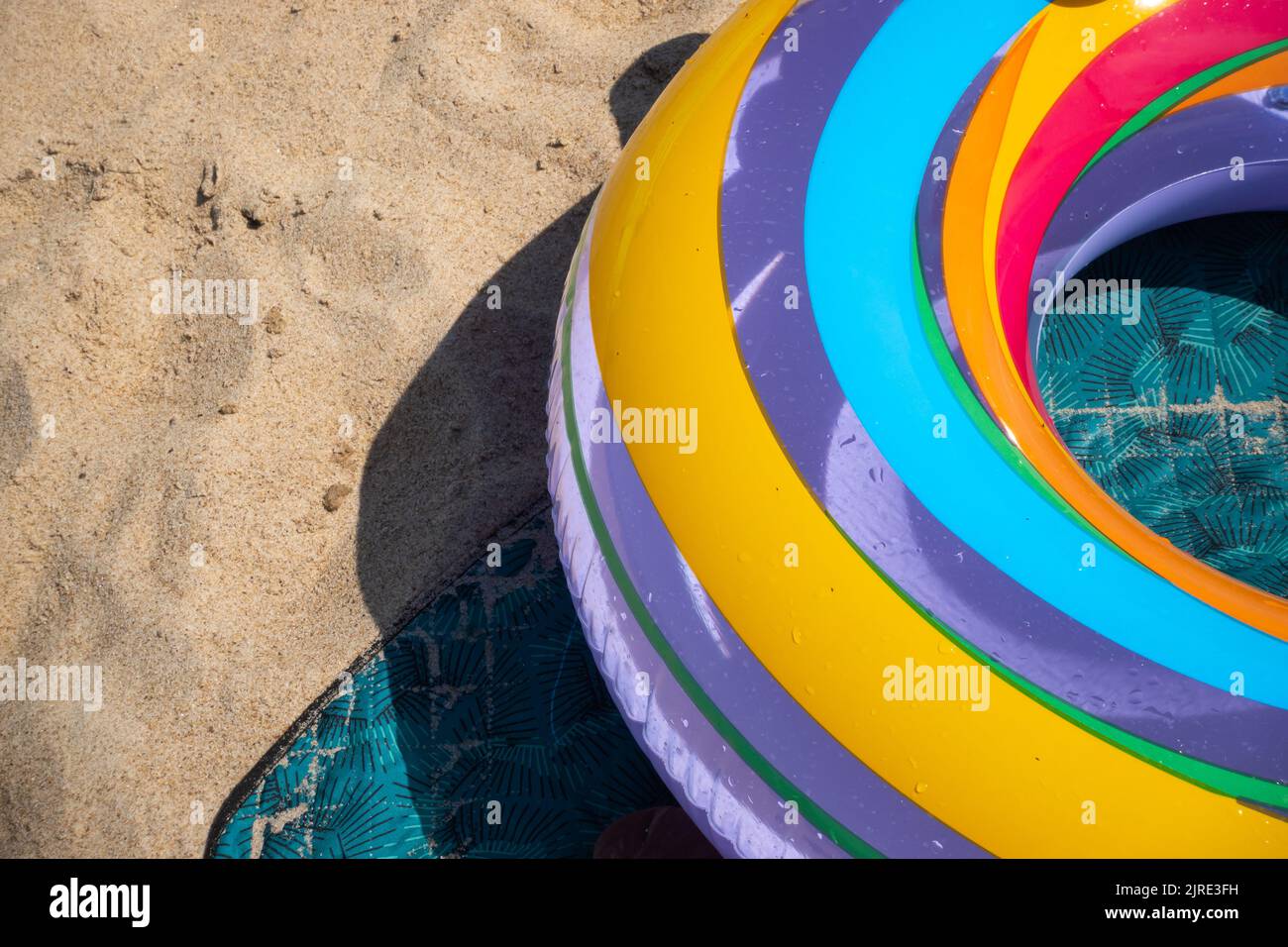 Colorful, inflatable beach wheel lying on the sand. Photo taken at noon ...