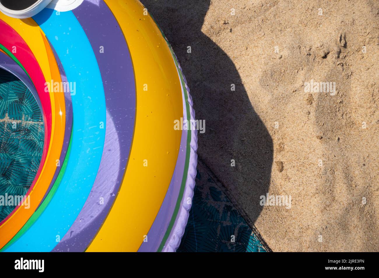 Colorful, inflatable beach wheel lying on the sand. Photo taken at noon ...