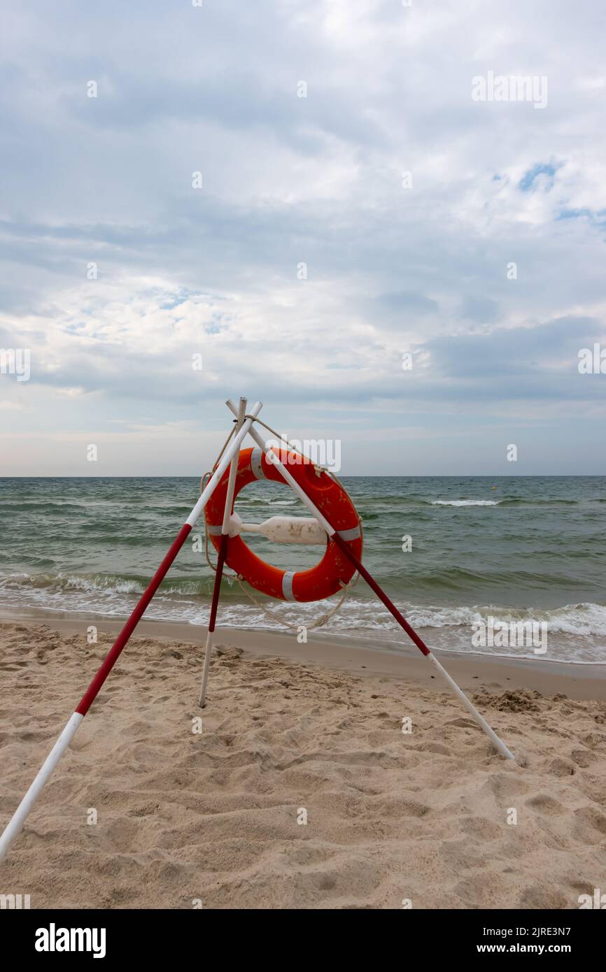 An orange lifeboat and reach extenders stuck in the sand on the beach ...