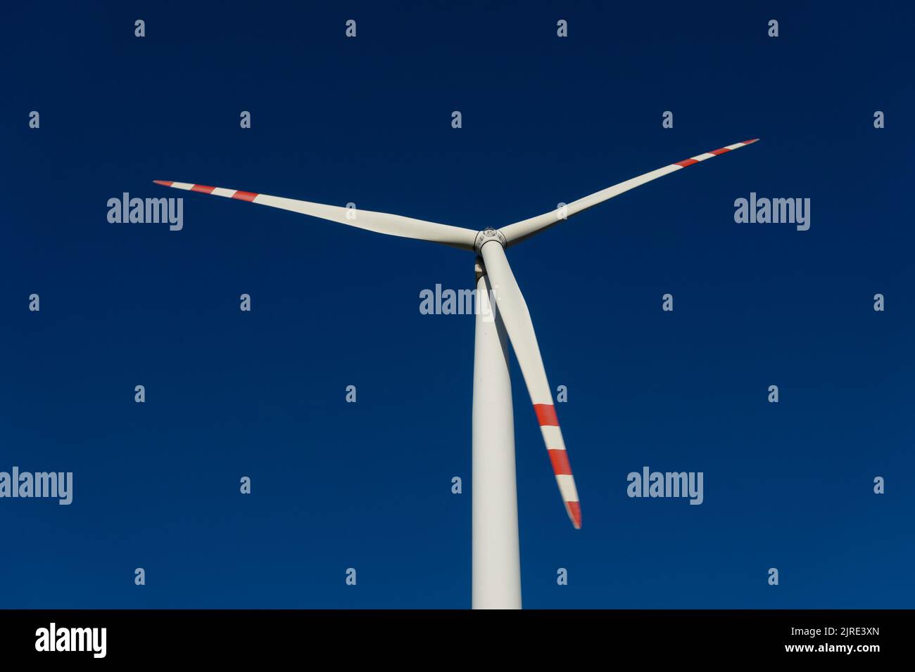 White blades of a wind turbine against the background of a navy blue ...
