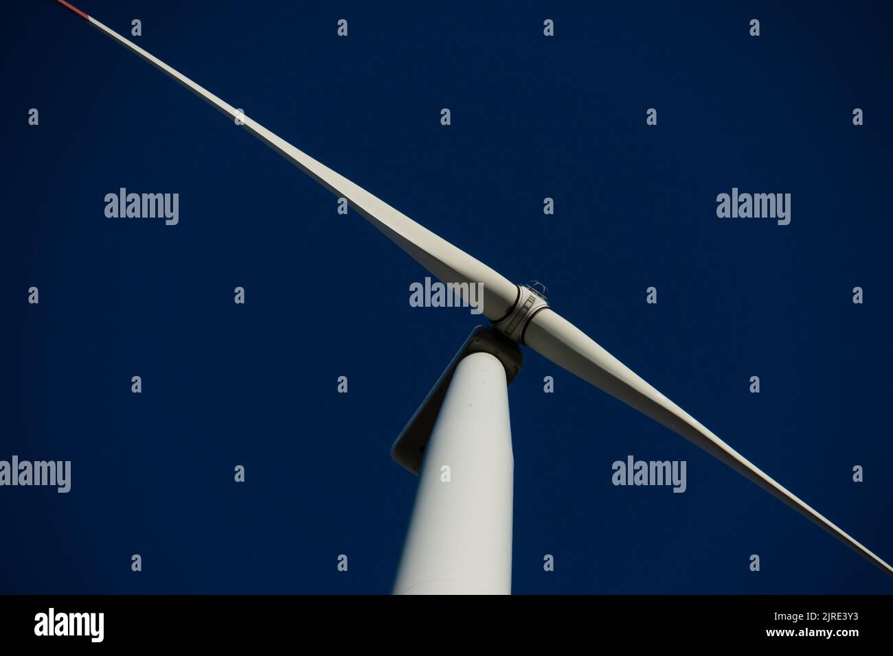White blades of a wind turbine against the background of a navy blue ...