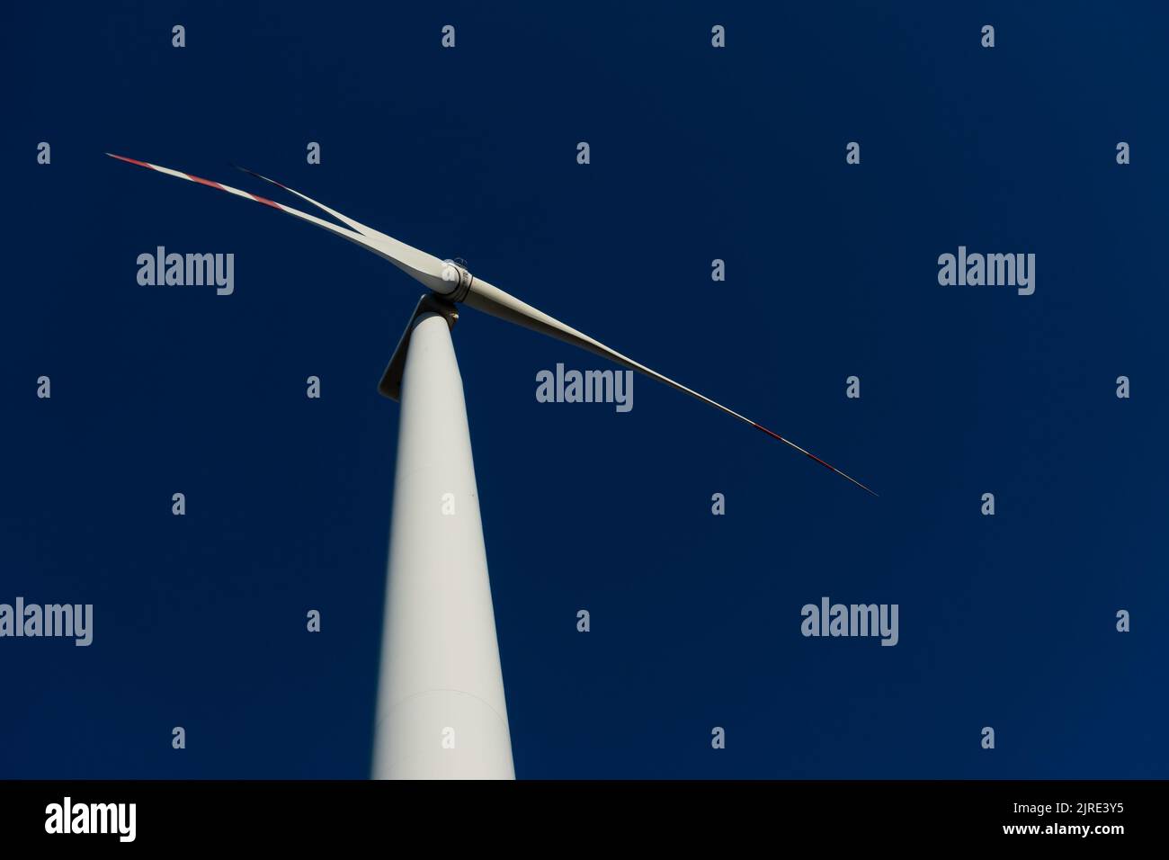 White blades of a wind turbine against the background of a navy blue ...