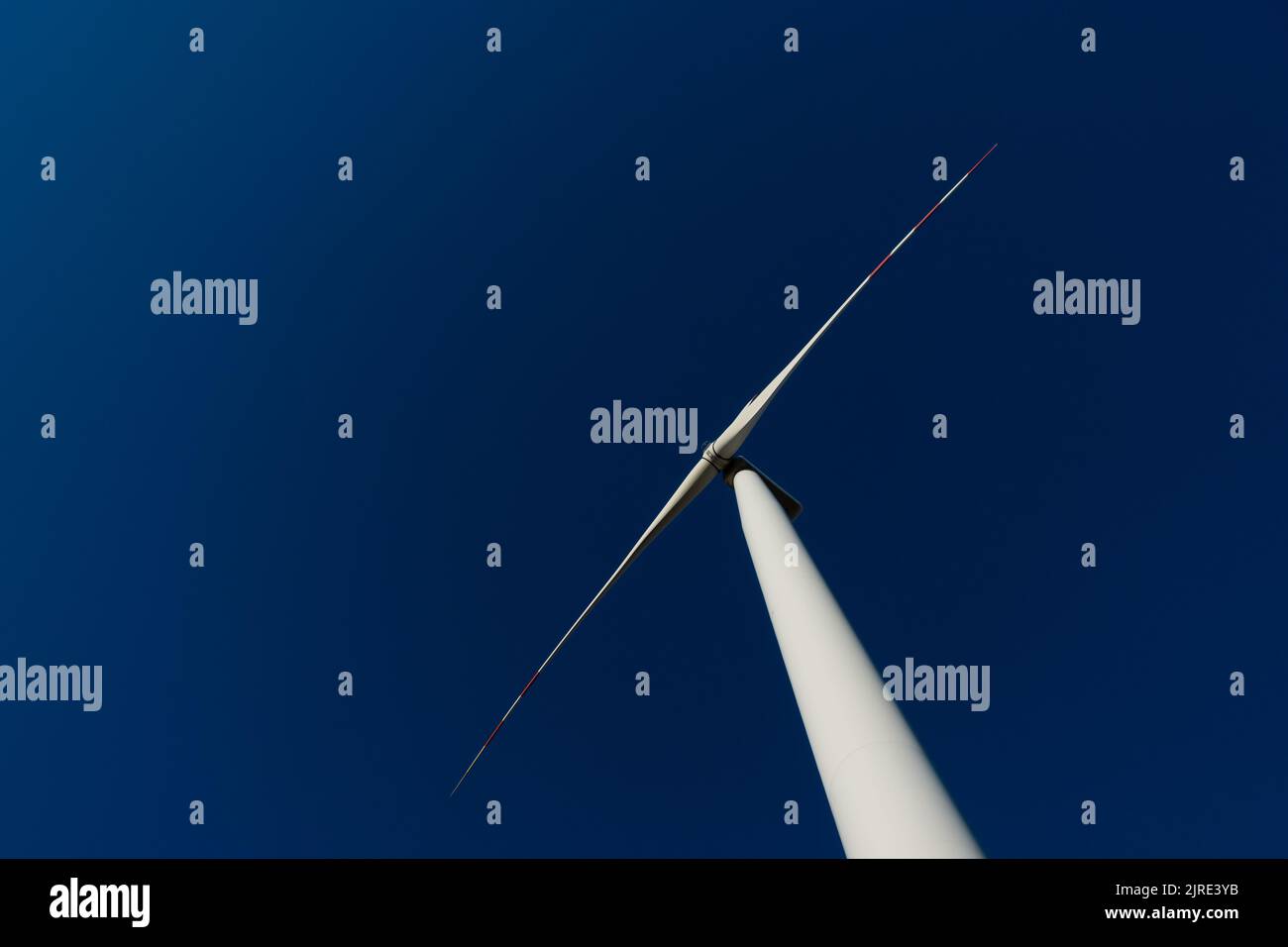 White blades of a wind turbine against the background of a navy blue ...