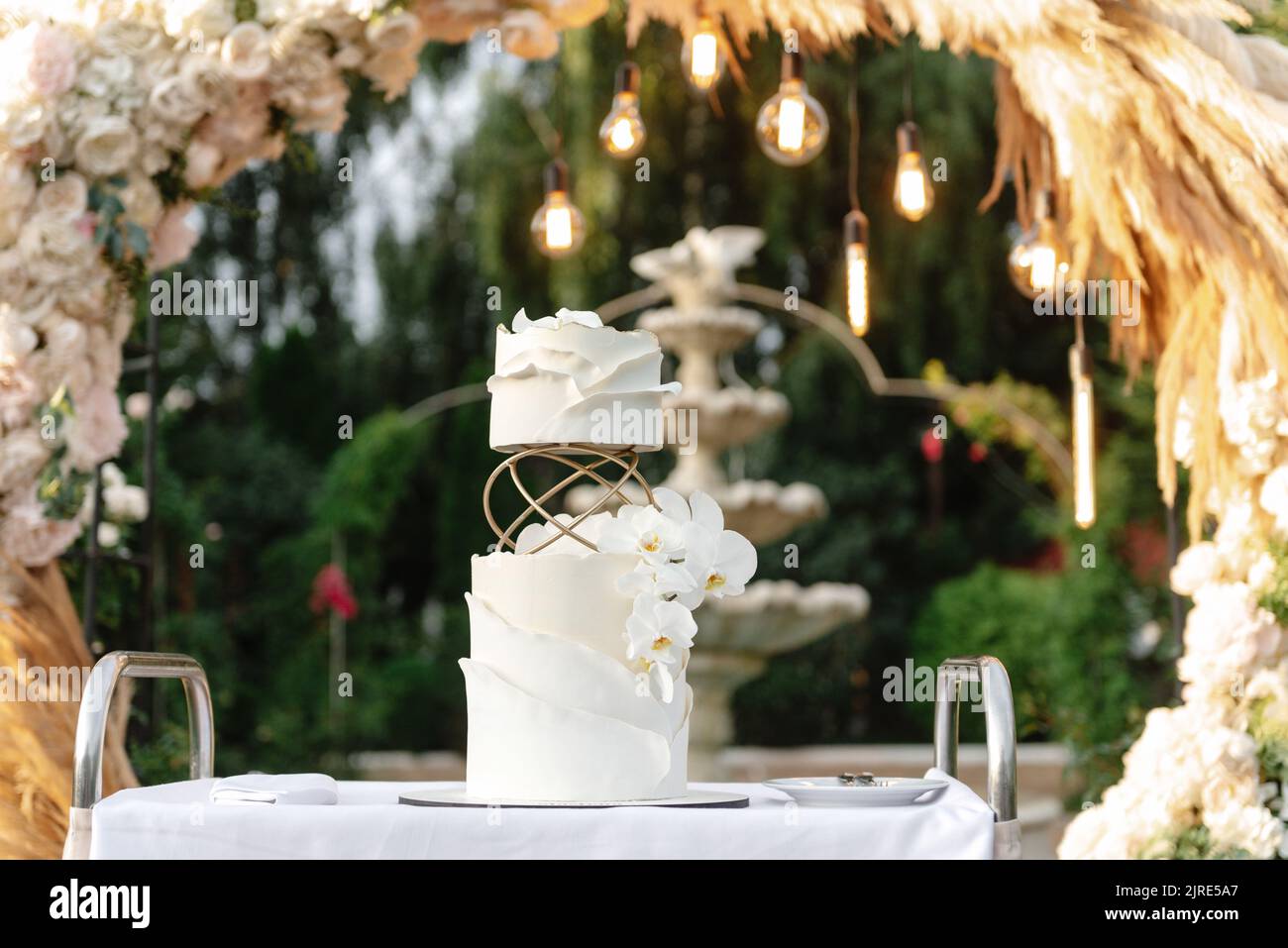 White wedding cake with flowers. Wedding cake on the background of the ...