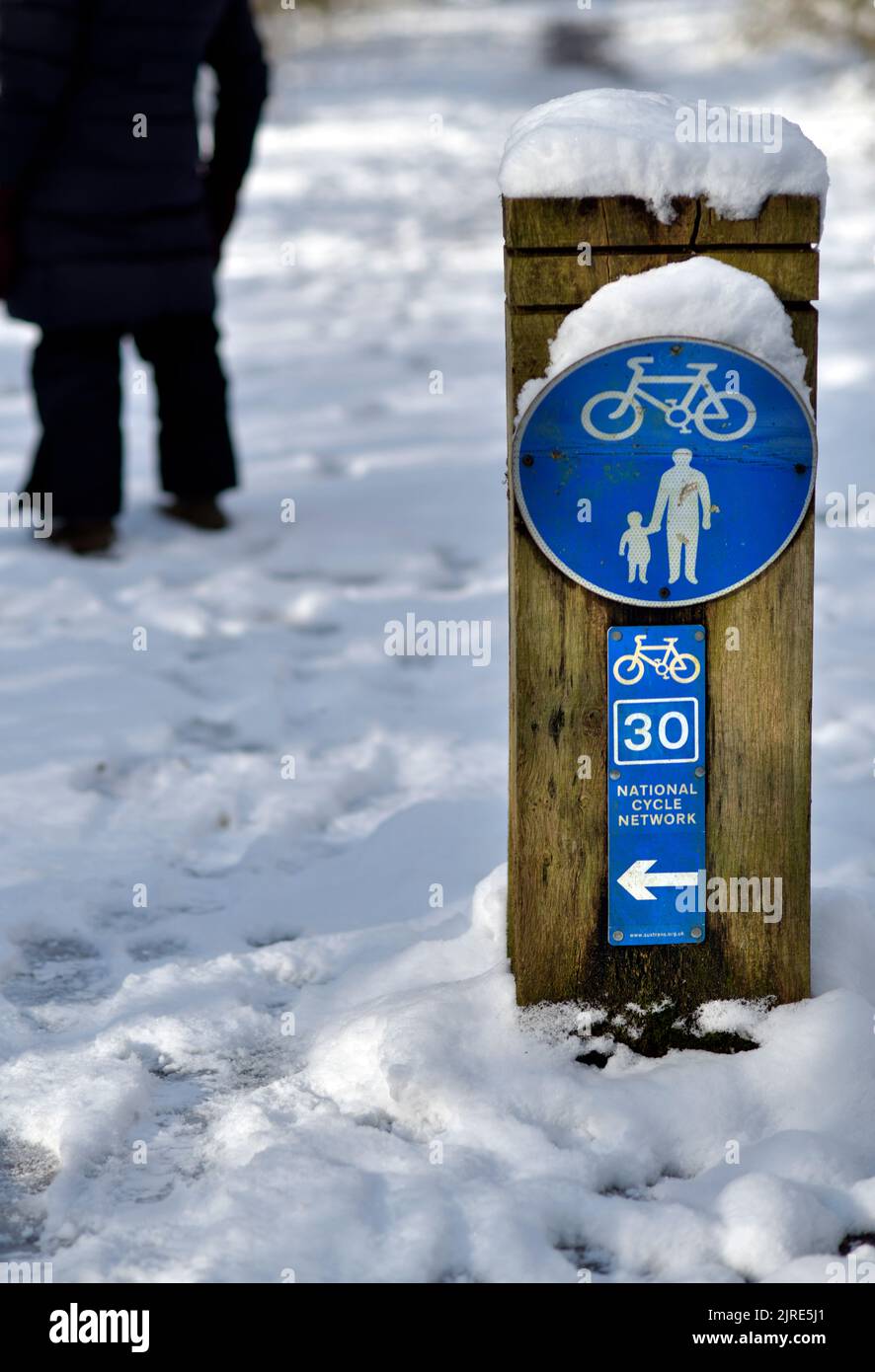 national cycle network track sign and dark figure in the snow Stock ...