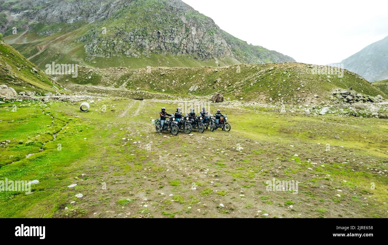 wide green aerial landscape of motorcycle tour group in mountains of ...
