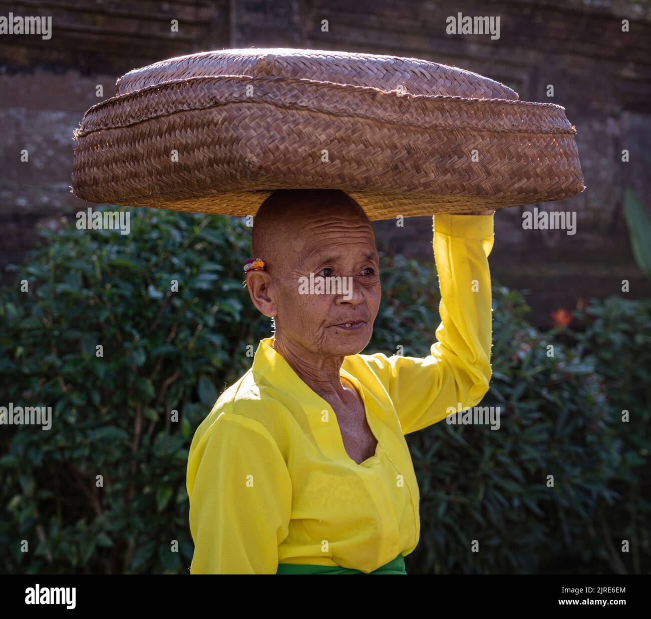 Woman carries basket on her head as she walks Stock Photo - Alamy