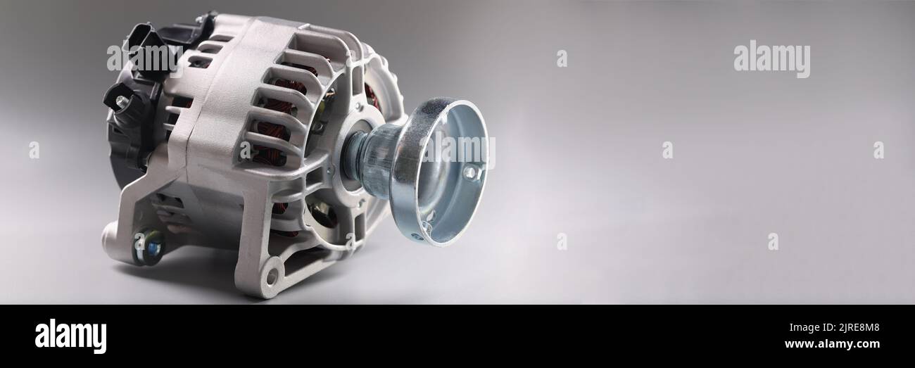 Metal motor with wire and plugs lies on grey surface, production of ...