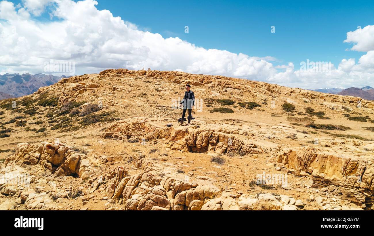 man with hands up on top of a high altitude mountain in Spiti Valley ...