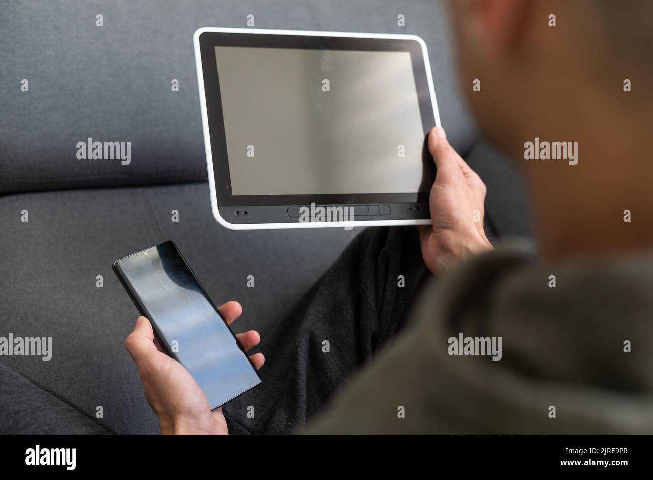 close up hands multitasking man using tablet, laptop and cellphone ...
