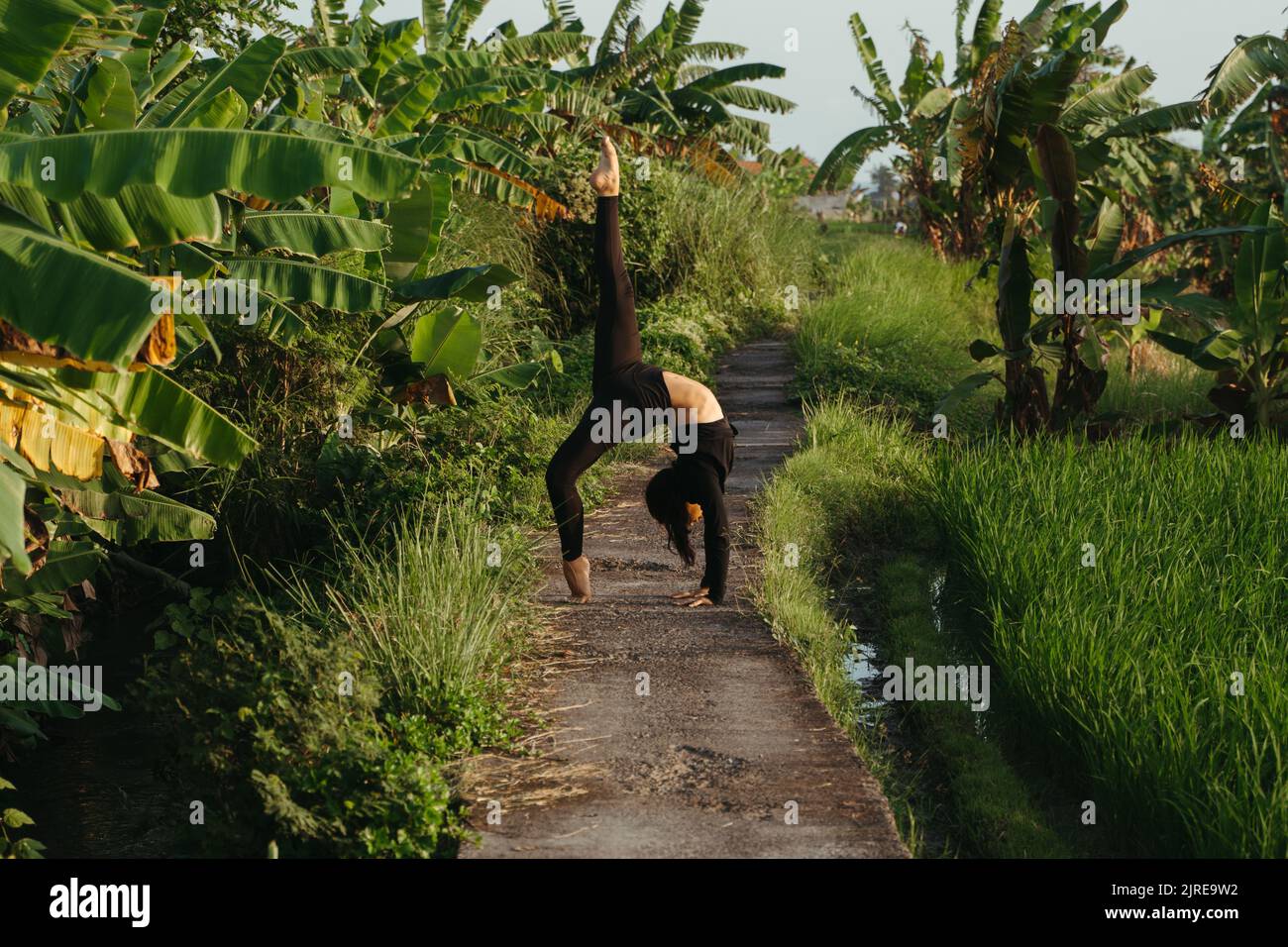 Yoga Bali. Sporty young woman doing yoga asana upward bow wheel pose ...