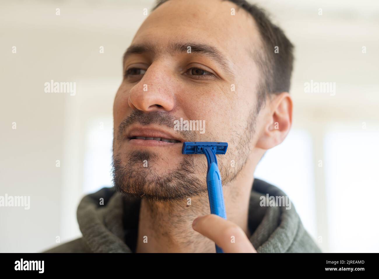Time for new razor. Closeup of a razor on his chin stubbly Stock Photo ...