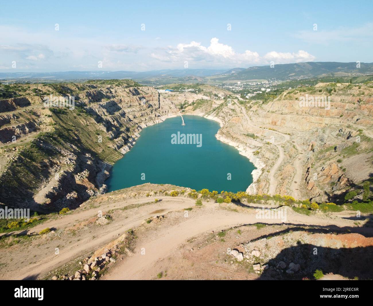 Aerial top view on opencast mining quarry with flooded bottom ...