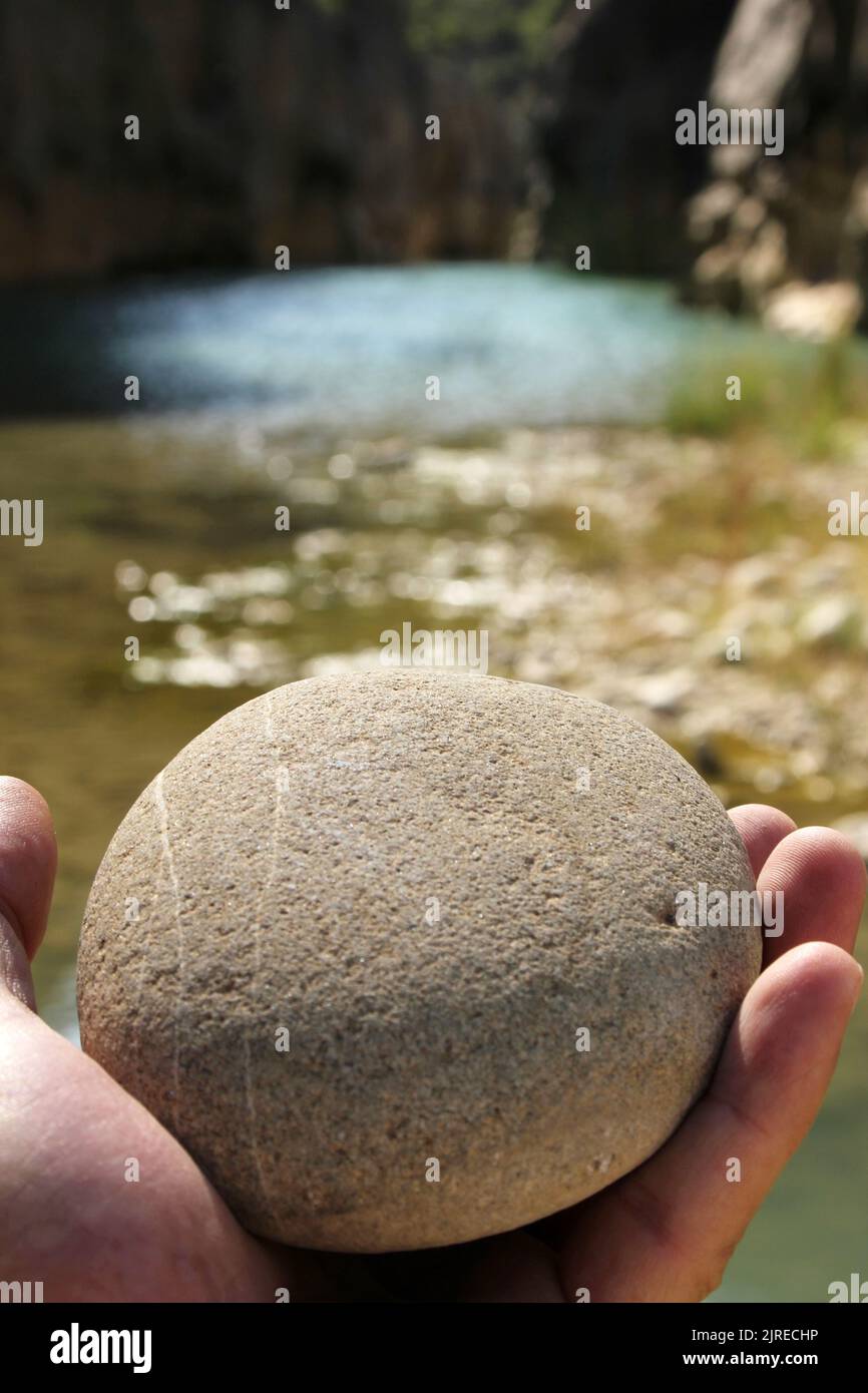 A hand holding a stone. Man and nature Stock Photo - Alamy