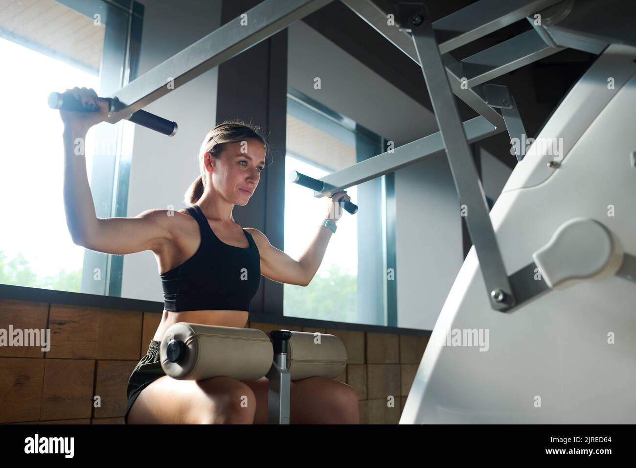Young fitness woman sitting and raising her arms, she training her ...