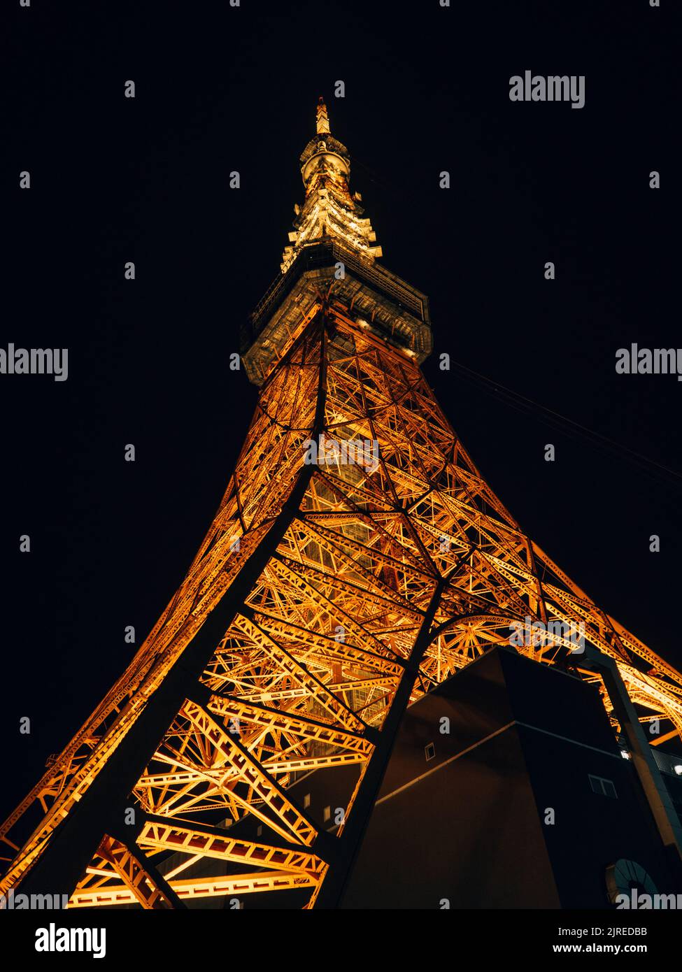 A vertical low angle shot of illuminated Tokyo Tower in Shiba Park at night Stock Photo - Alamy