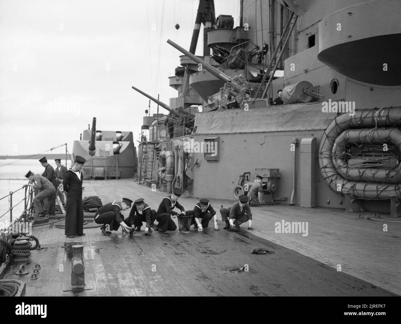 Sailors scrubbing the deck on board HMS RODNEY, 1940. Sailors on hands ...
