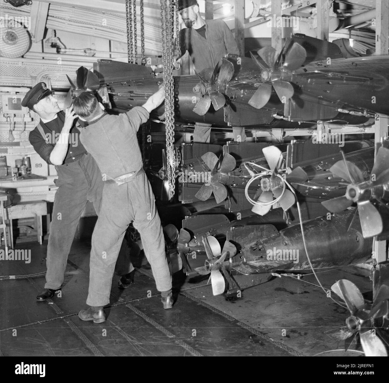 Sailors hauling out a torpedo from the stores of the depot ship HMS ...