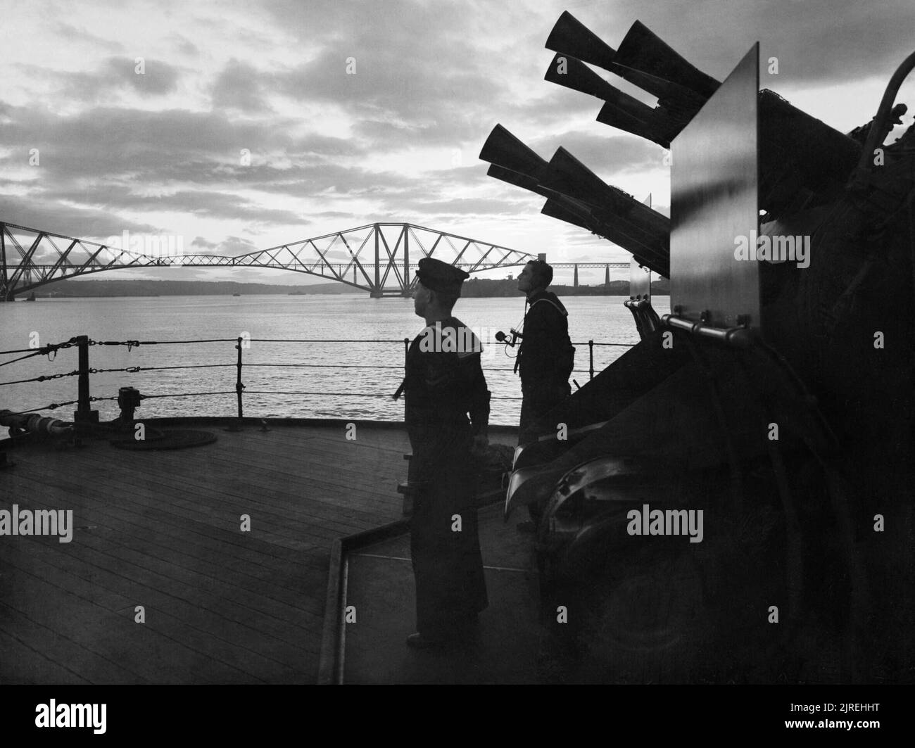 An eight-barrelled two-pounder 'pom-pom' gun on HMS RODNEY silhouetted ...