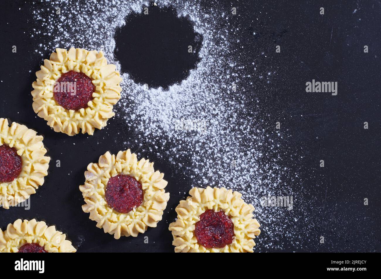 Fresh batch of cookies with filling on old black metal background ...