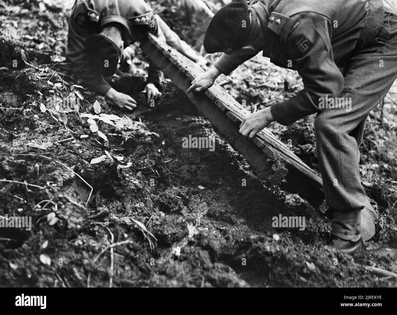 The Royal Navy during the Second World War Two man setting a booby trap ...