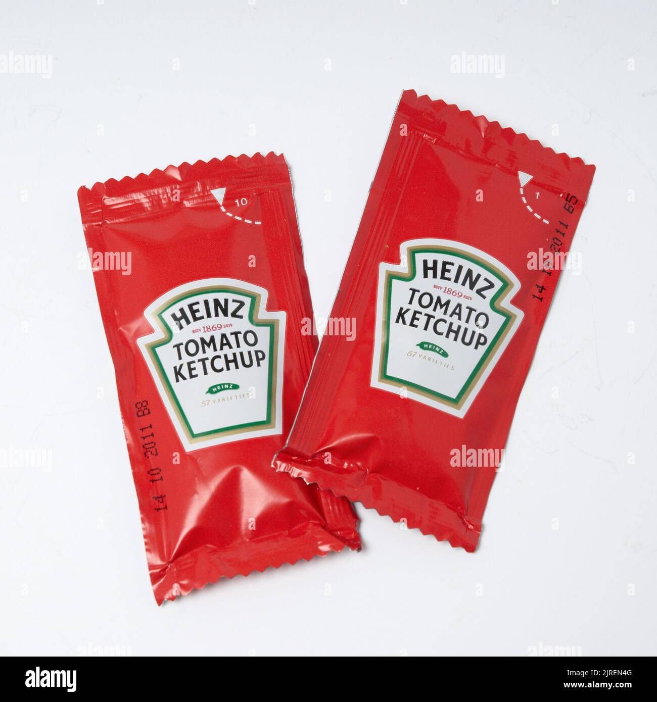 Two sachets of Heinz Tomato Ketchup isolated on white background cut ...