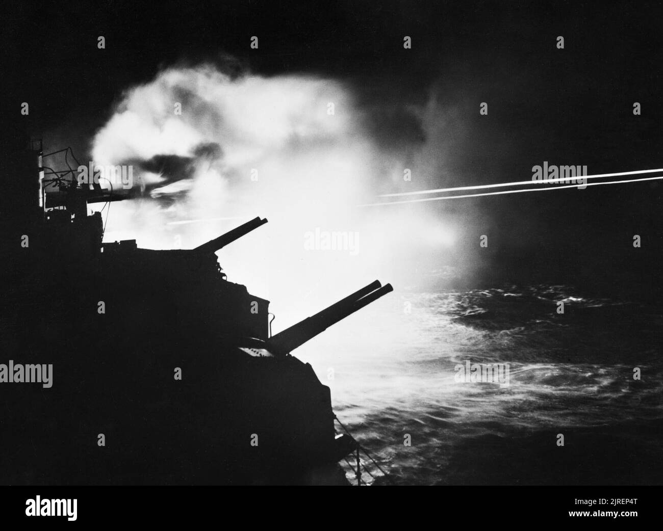 HMS MAURITIUS firing during a night action against enemy ships off the ...