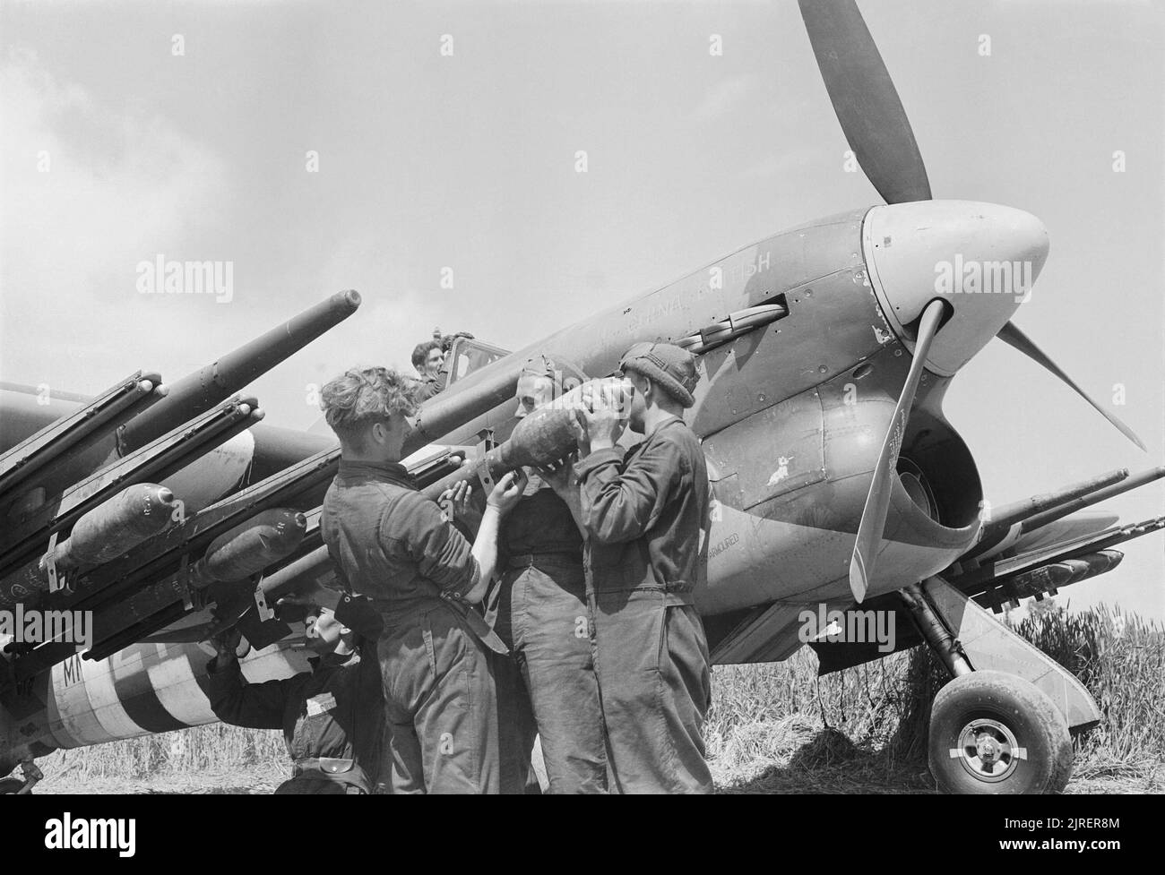 Ground crews loading 3-inch rocket projectiles onto a Hawker Typhoon Mk ...